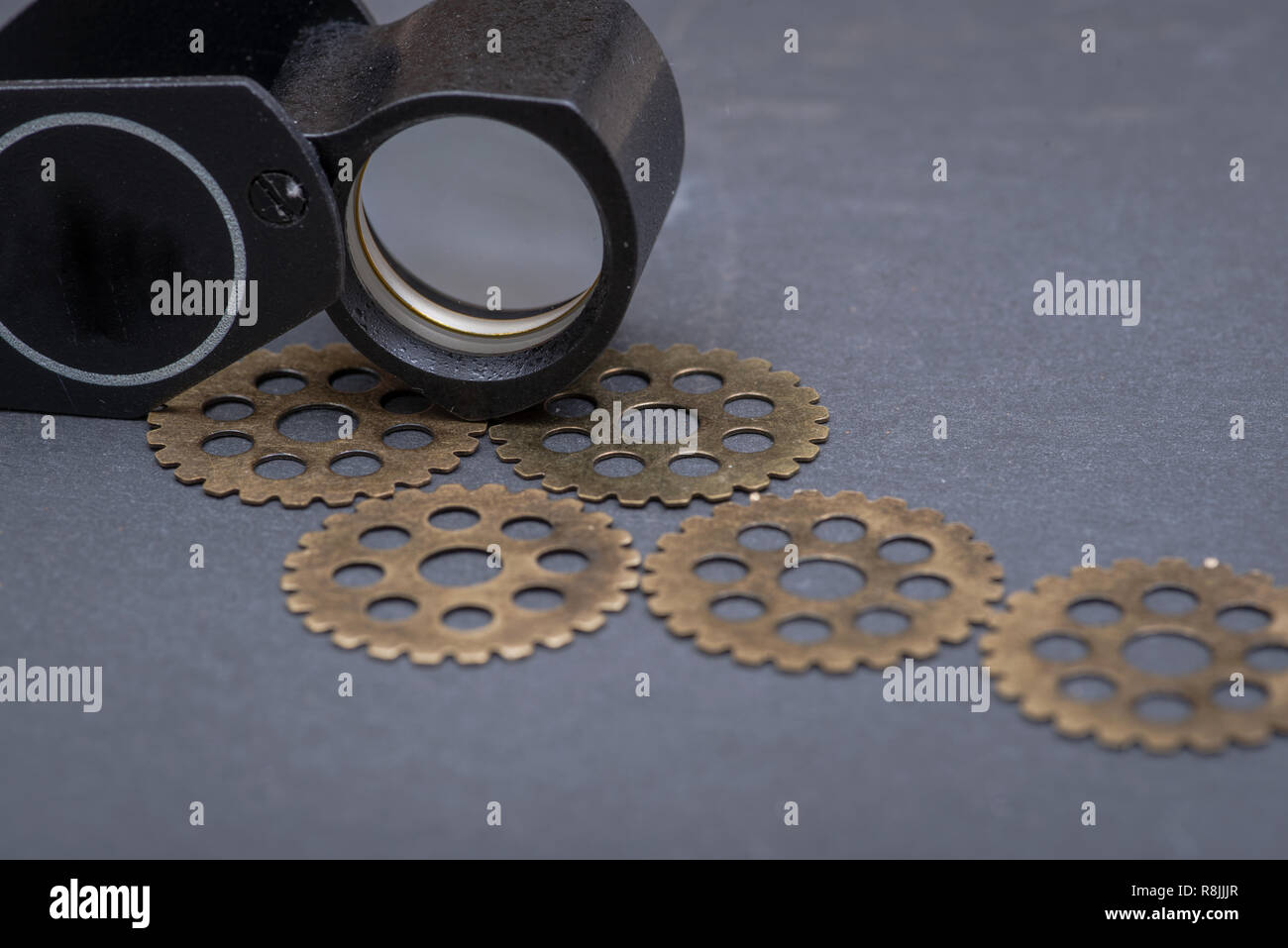 Loupe, magnifying glass and old vintage antique hour metal gears ...