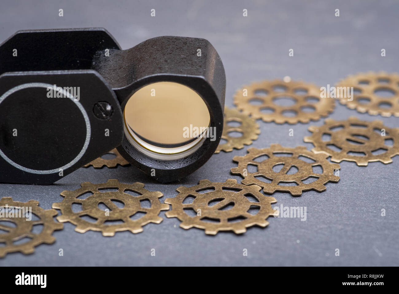 Loupe, magnifying glass and old vintage antique hour metal gears ...