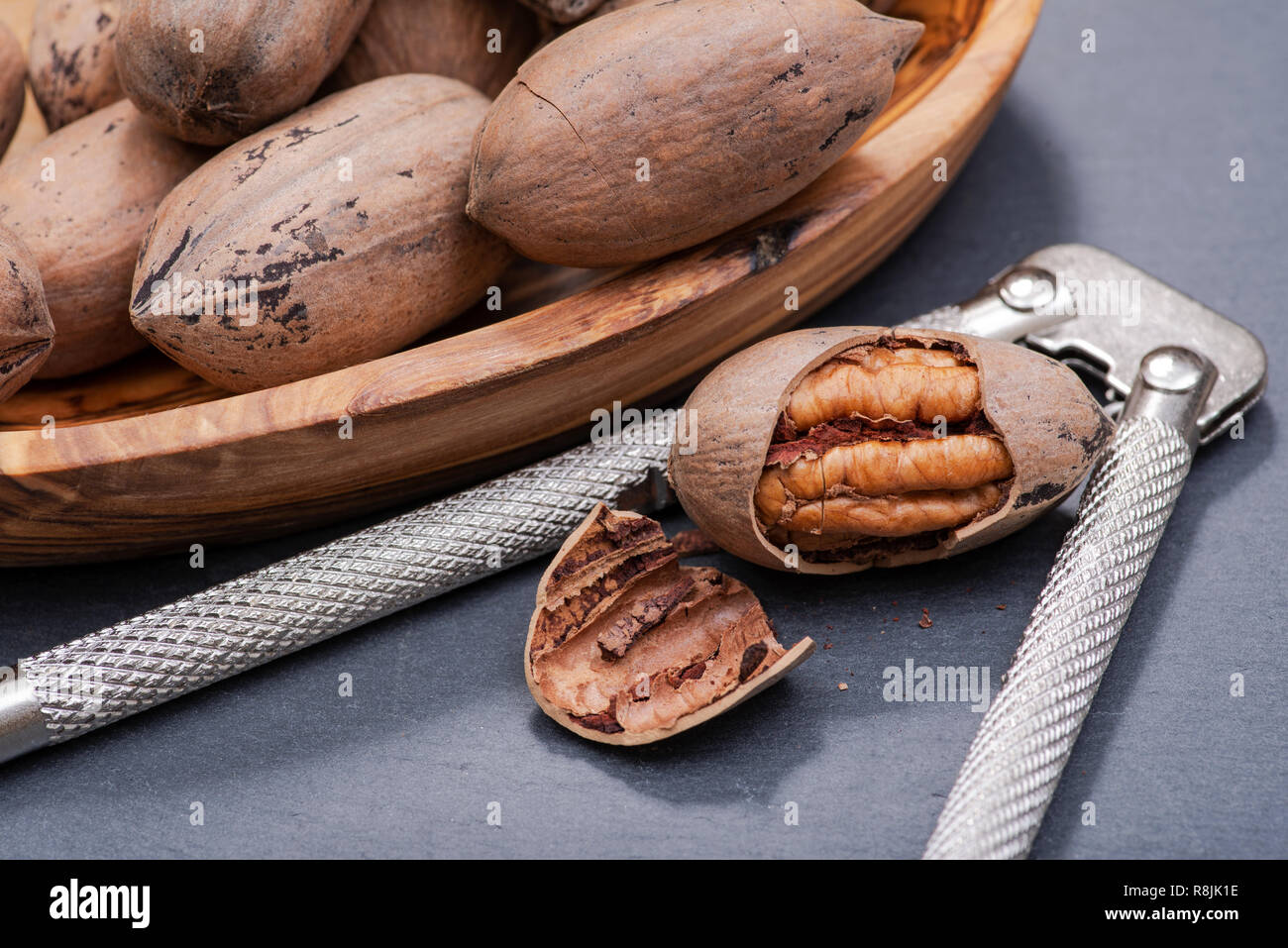 Fresh organic pecans nuts and stainless steel nutcracker on natural ...