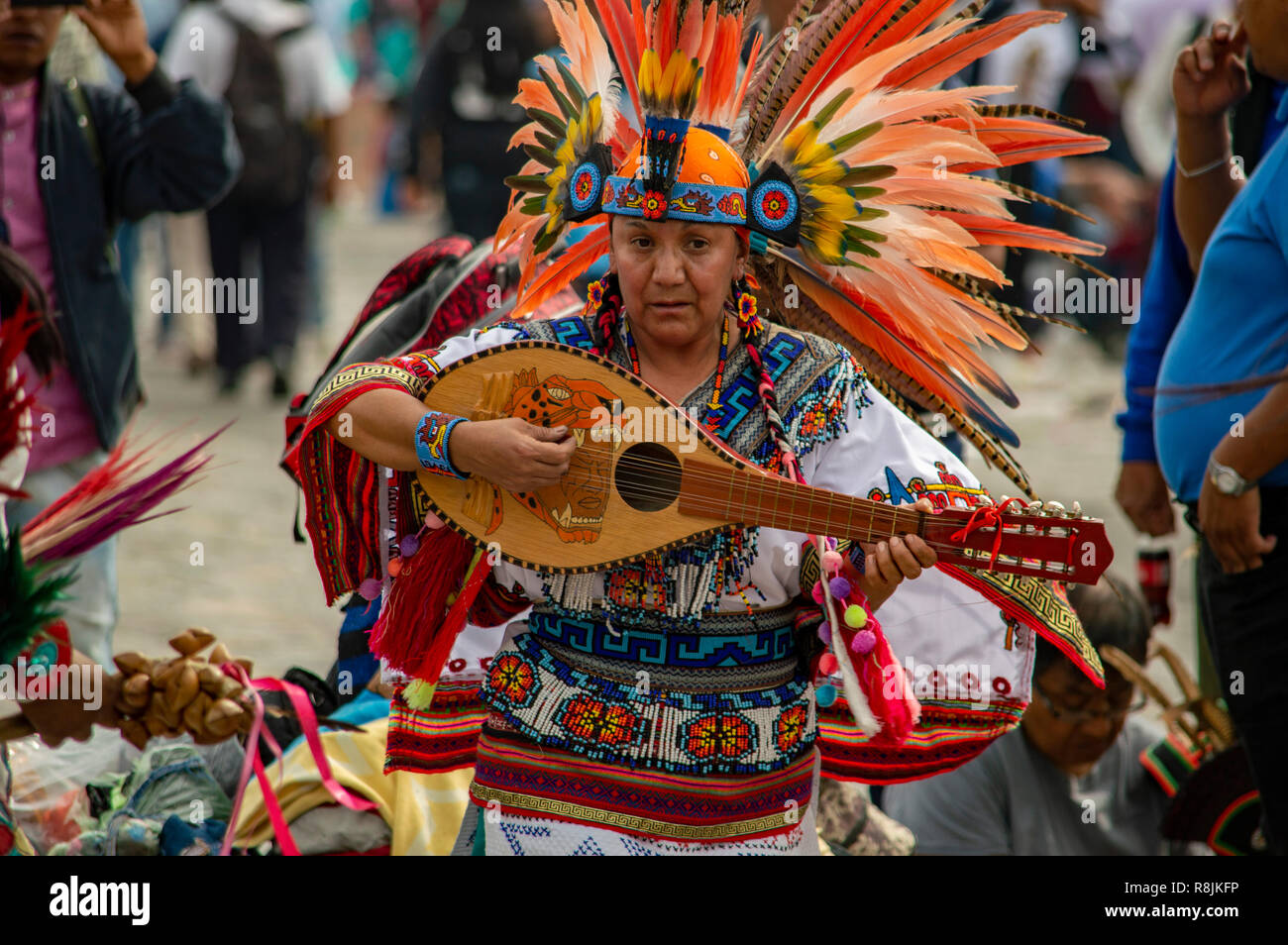 A Mexican woman playing a traditional stringed instrument at the ...