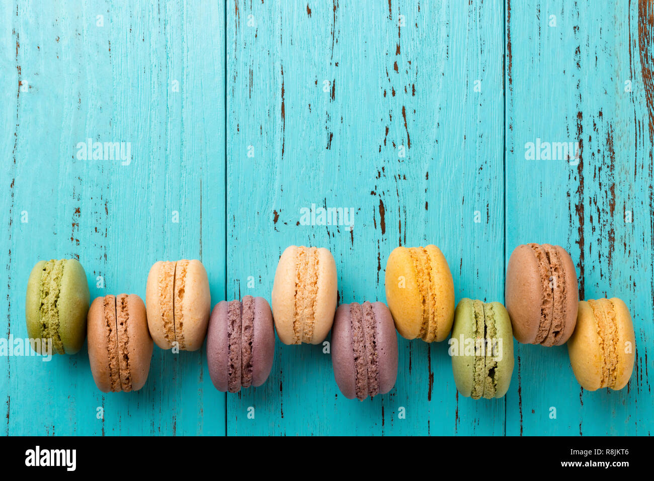 studio shoot of colorful macaroons line up on a blue background with ...