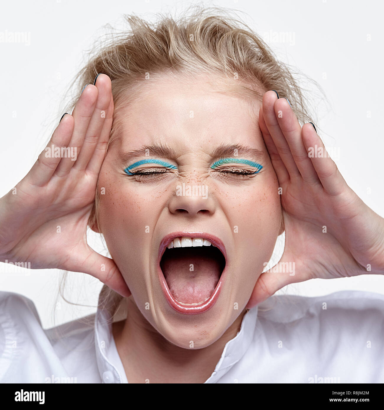 Emotional portrait of a young blonde woman on gray background. Female ...