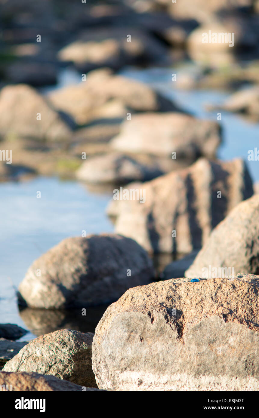 Blue pebble isolated at dusk in a rocky creek as the light starts to ...