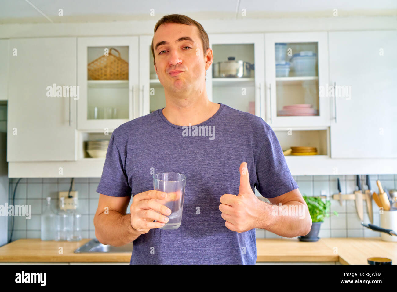 Handsome guy posing - drinking water and thumbs up Stock Photo - Alamy