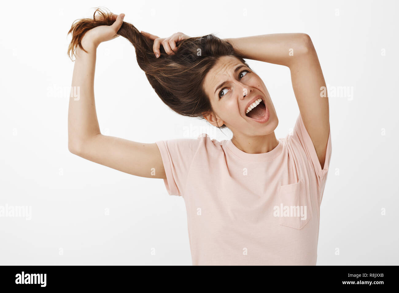 Girl feeling annoyed as trying comb unruly hair pulling strands with ...