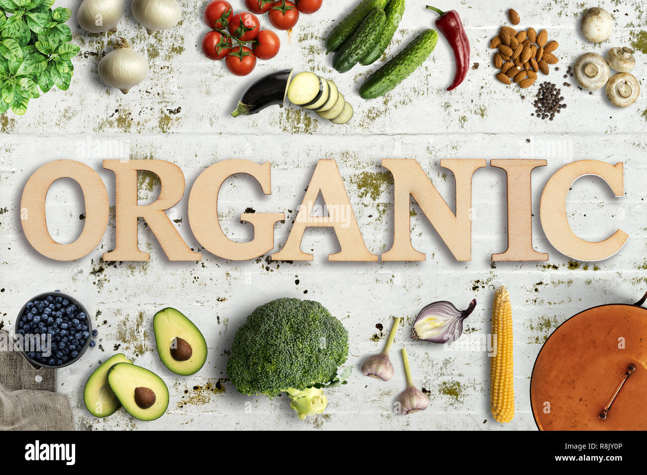 Word "Organic" in wooden letters with many cooking ingredients on solid ...