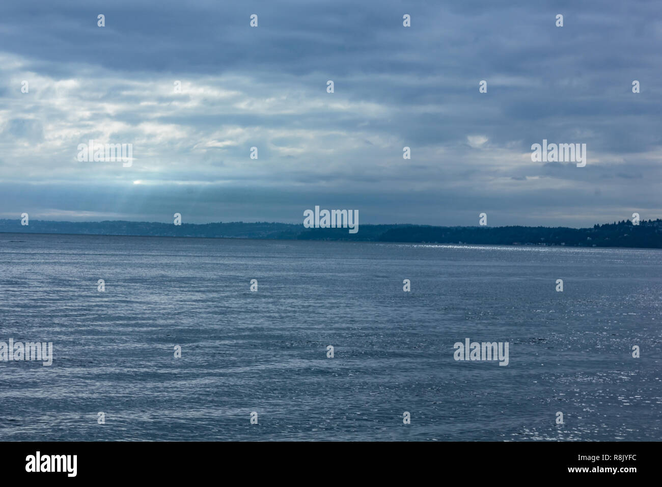 blue morning clouds letting silver sunlight fall on puget sound Stock ...