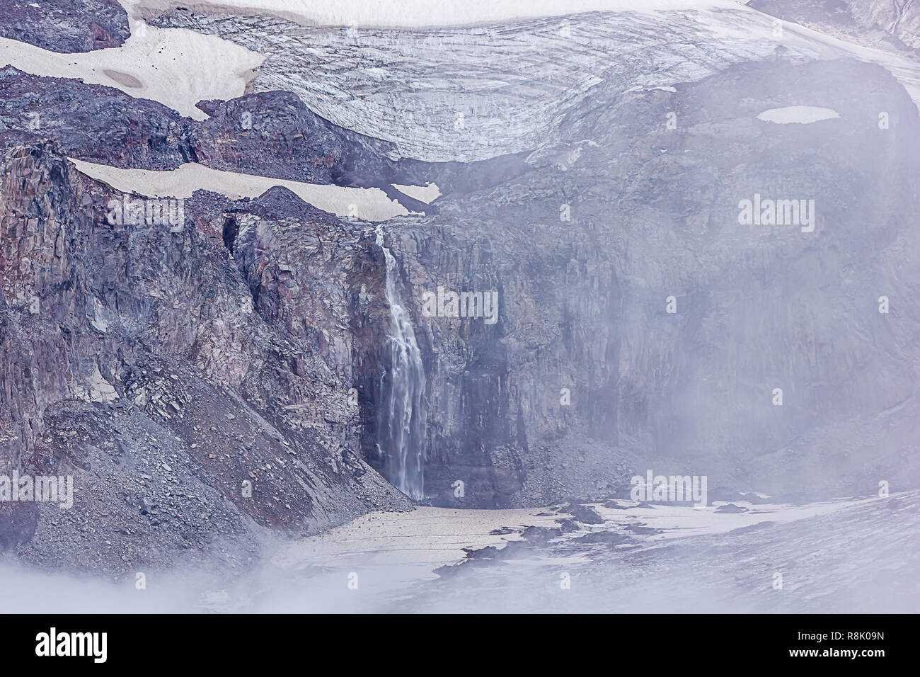 waterfall from glacial melt tumbled down long drop of harsh shale and ...