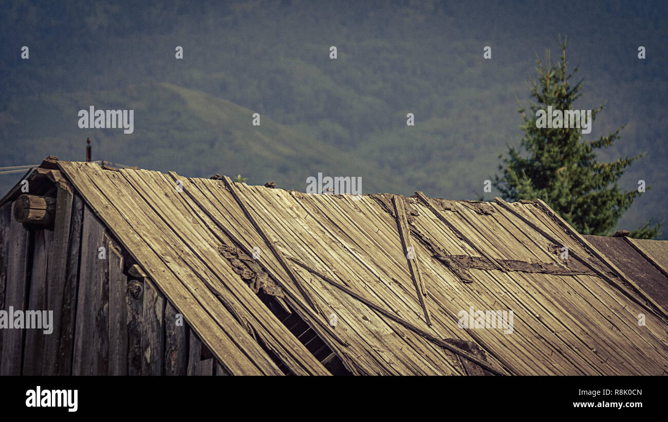 Vintage faded image of an old wooden barn roof falling apart dew to ...