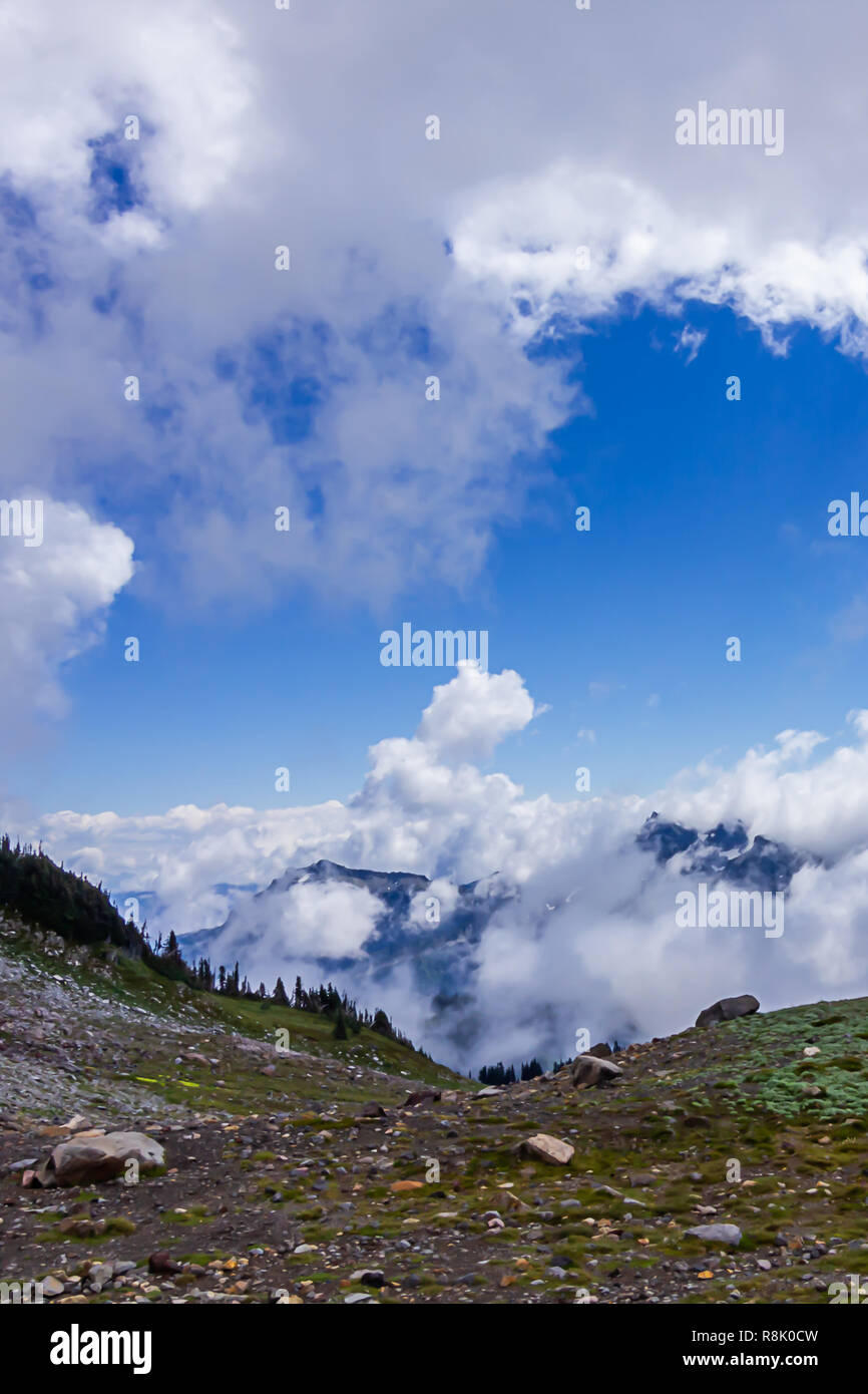 tall distant mountain range clouds and blue skys from rocky lookout ...