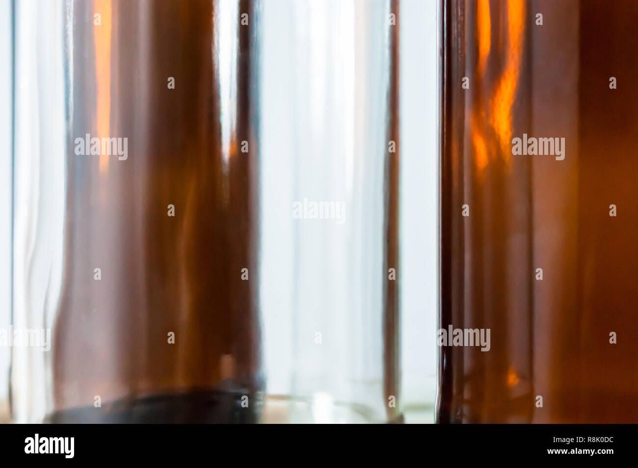 Glass bottles background with sun reflections on surface Stock Photo ...
