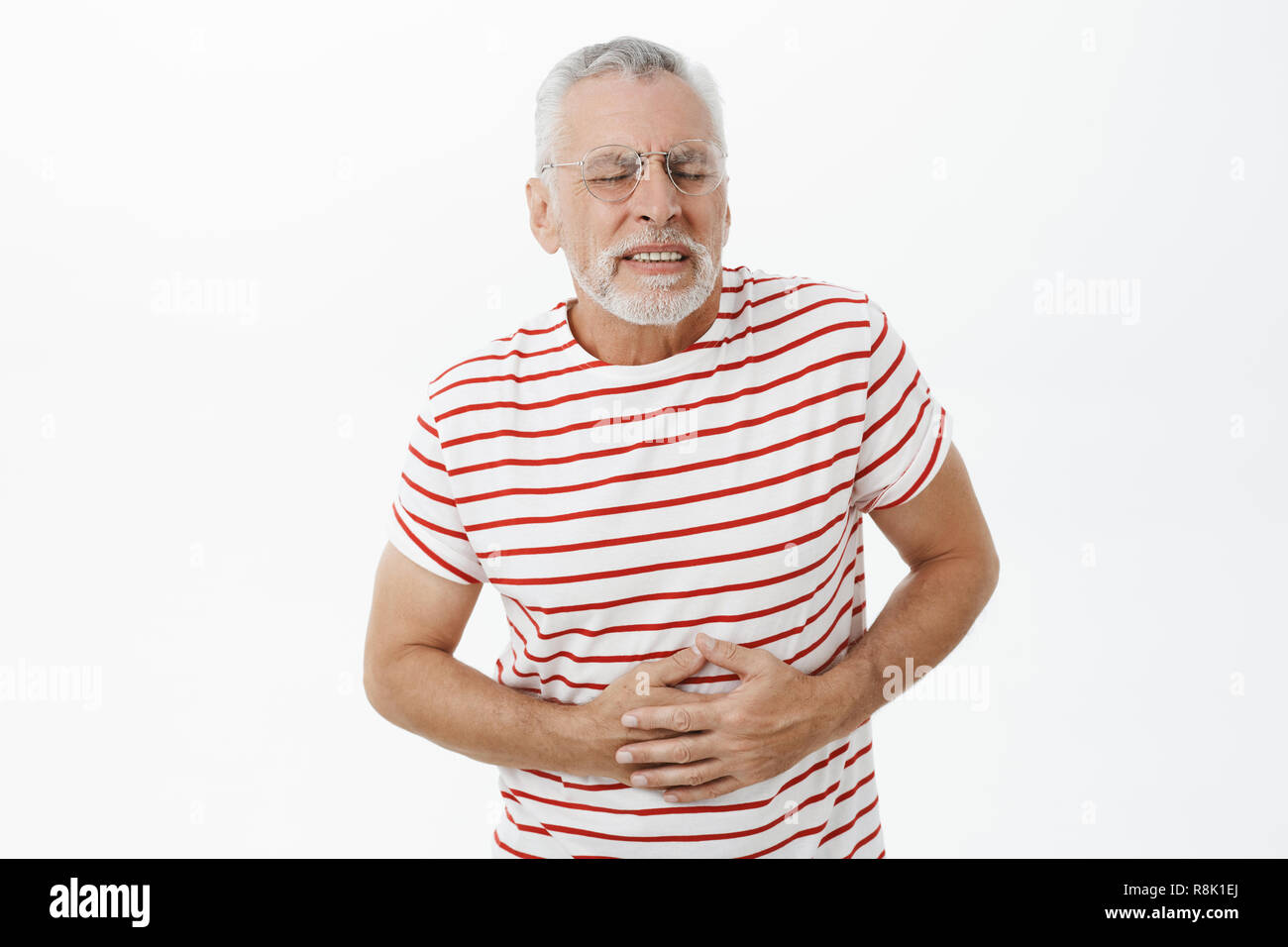 Portrait of intense bothered old man with grey beard and hair in ...
