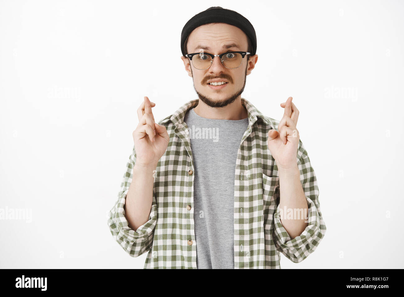 Faithful and hopeful stylish young bearded man in glasses and black ...