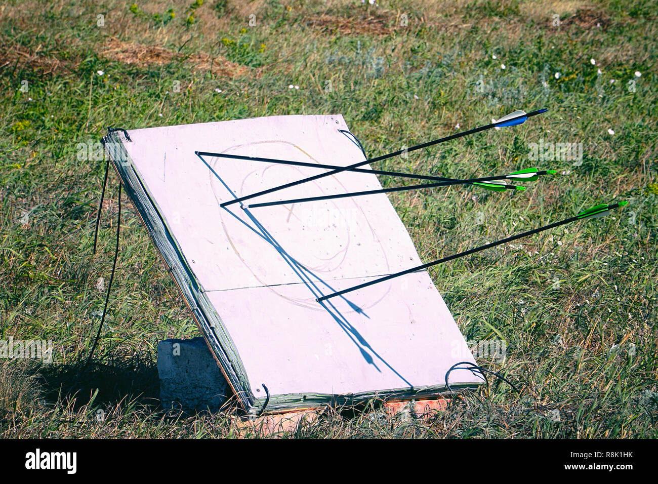 Arrows fired from a bow in a painted target Stock Photo - Alamy