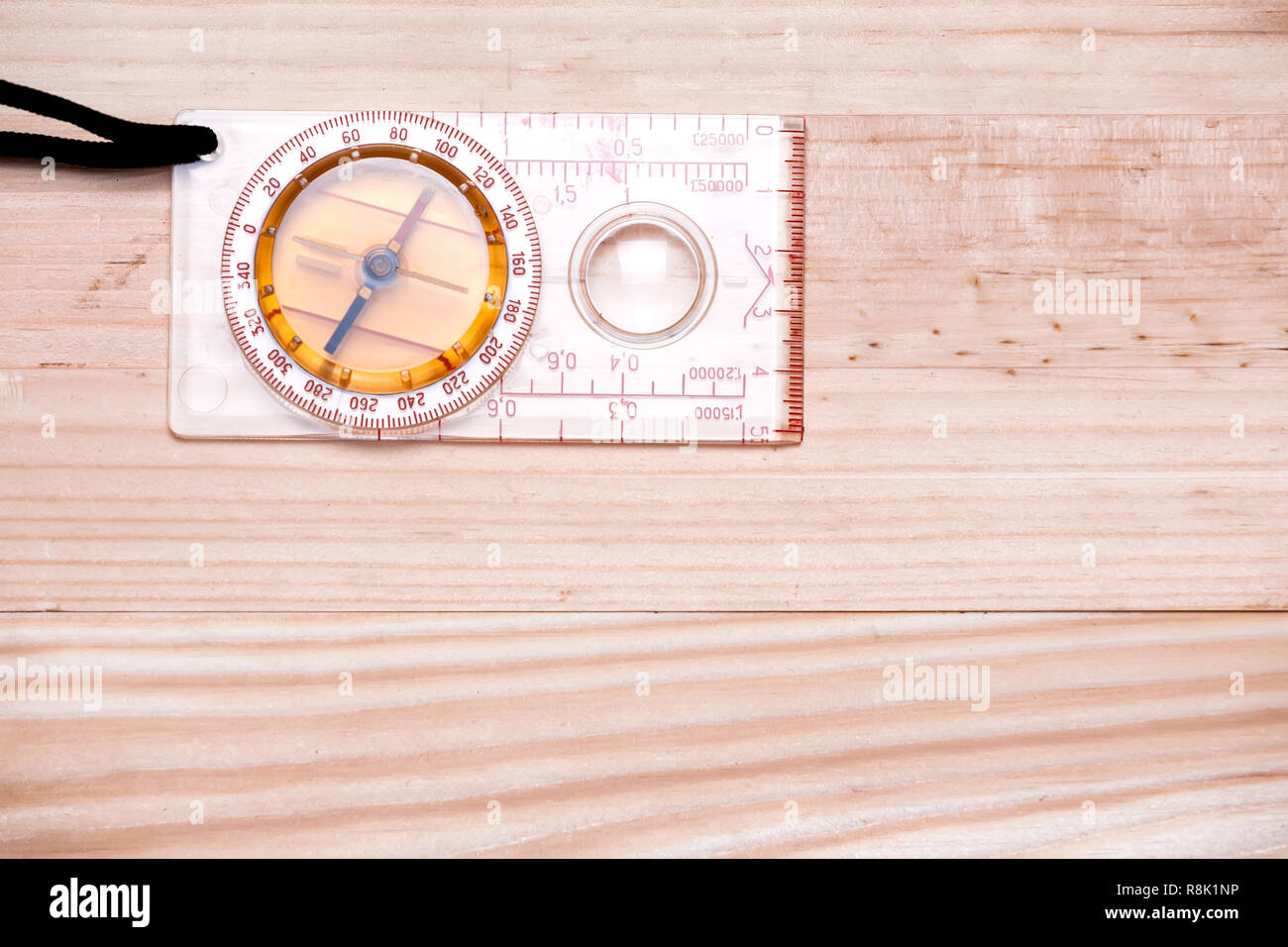Compass in top left corner on a light wooden background. Copy space ...