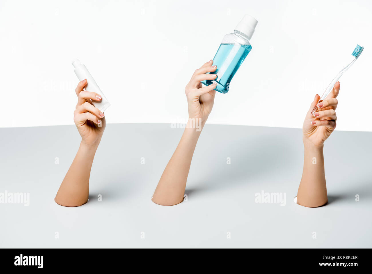 partial view of women holding toothpaste, toothbrush and mouthwash ...