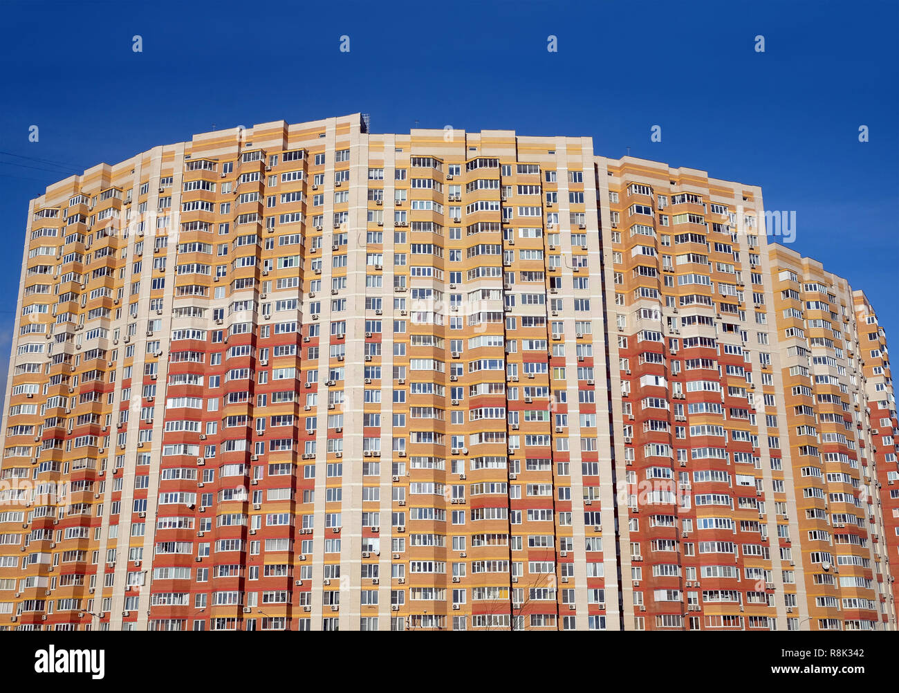 Facade of a large multi-storey block of flats with many apartments over ...