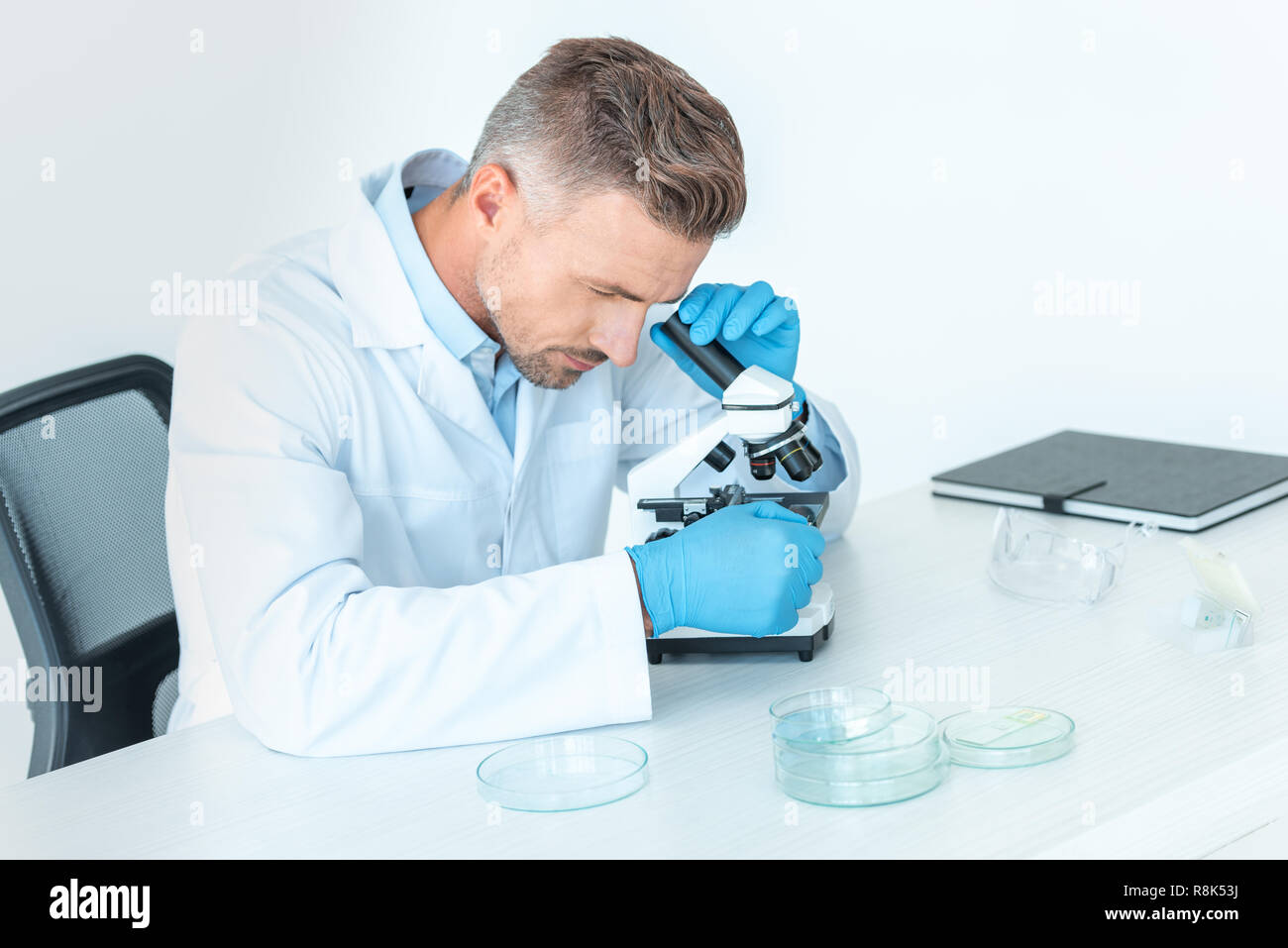 handsome chemist making test with microscope isolated on white Stock ...