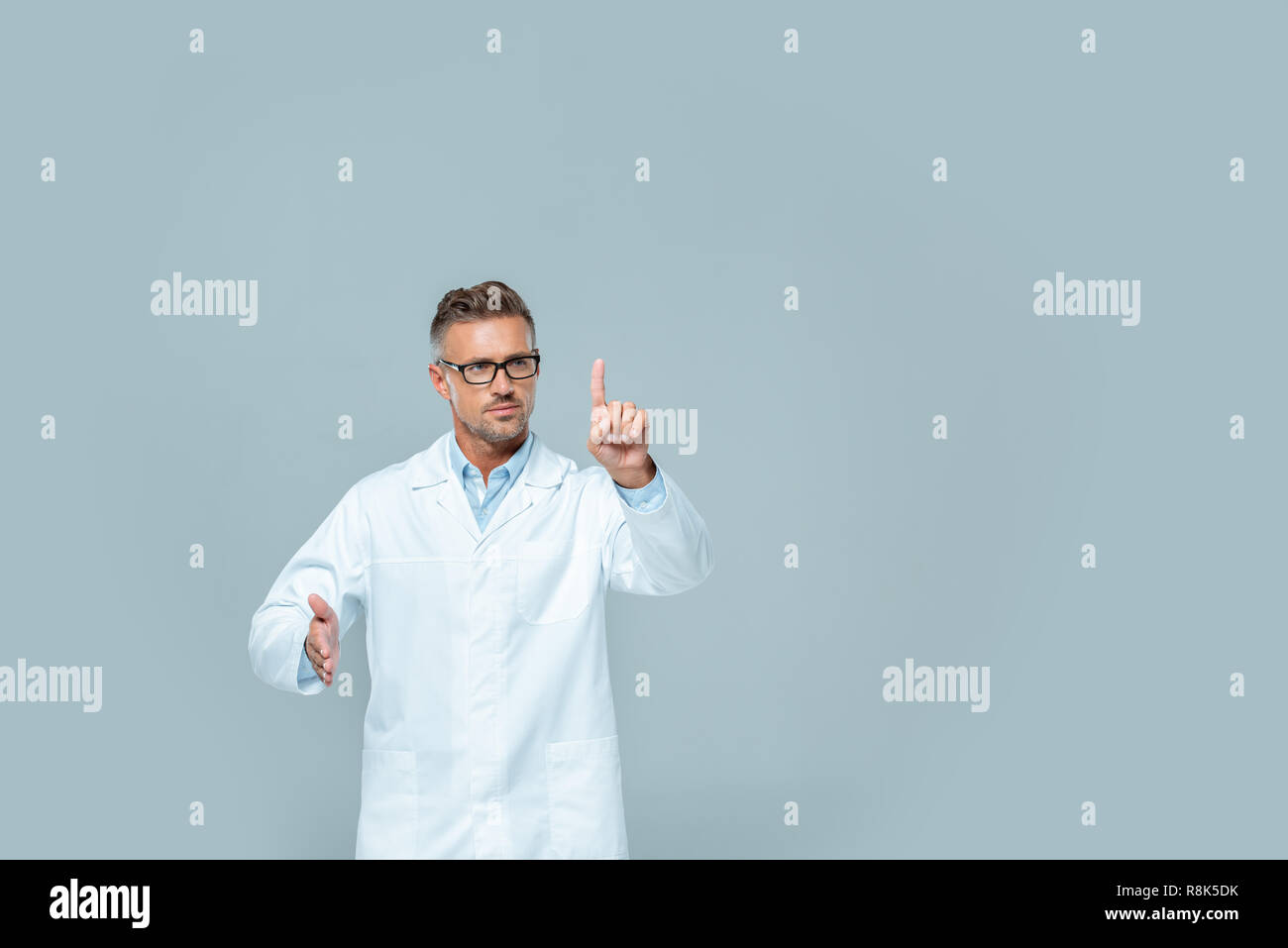 handsome scientist in glasses touching something in air isolated on ...