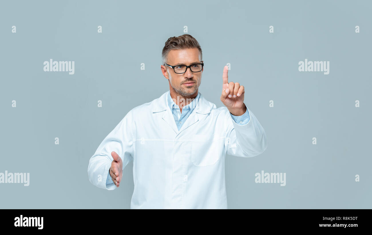 handsome scientist in glasses touching something isolated on grey ...