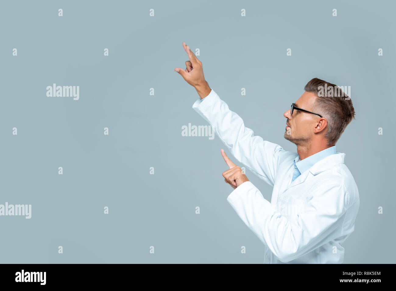 side view of handsome scientist in glasses moving something isolated on ...