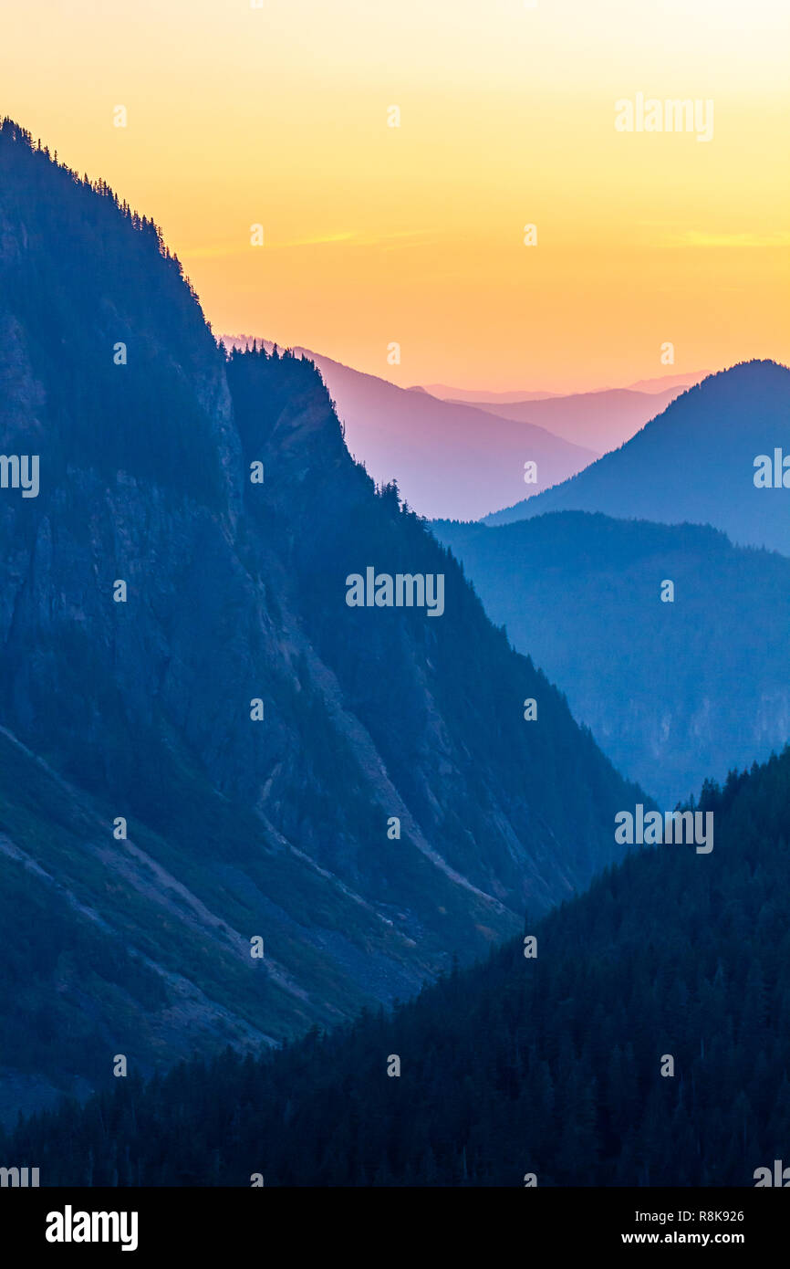 hazy blue and orange layered mountain sunset Stock Photo - Alamy