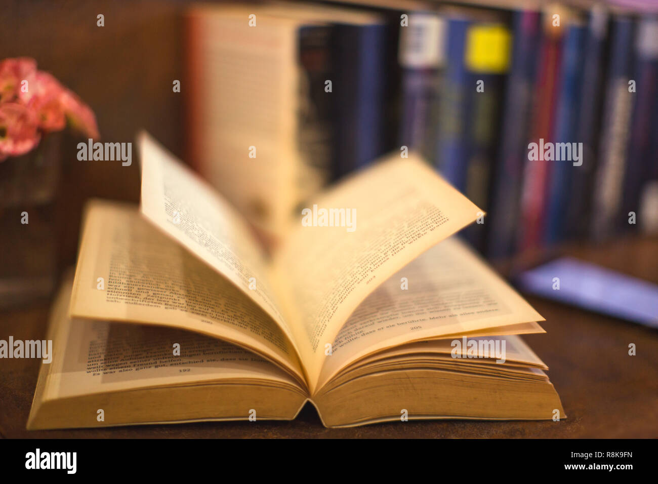 an open book with open pages and mobile phone and flower and books in ...