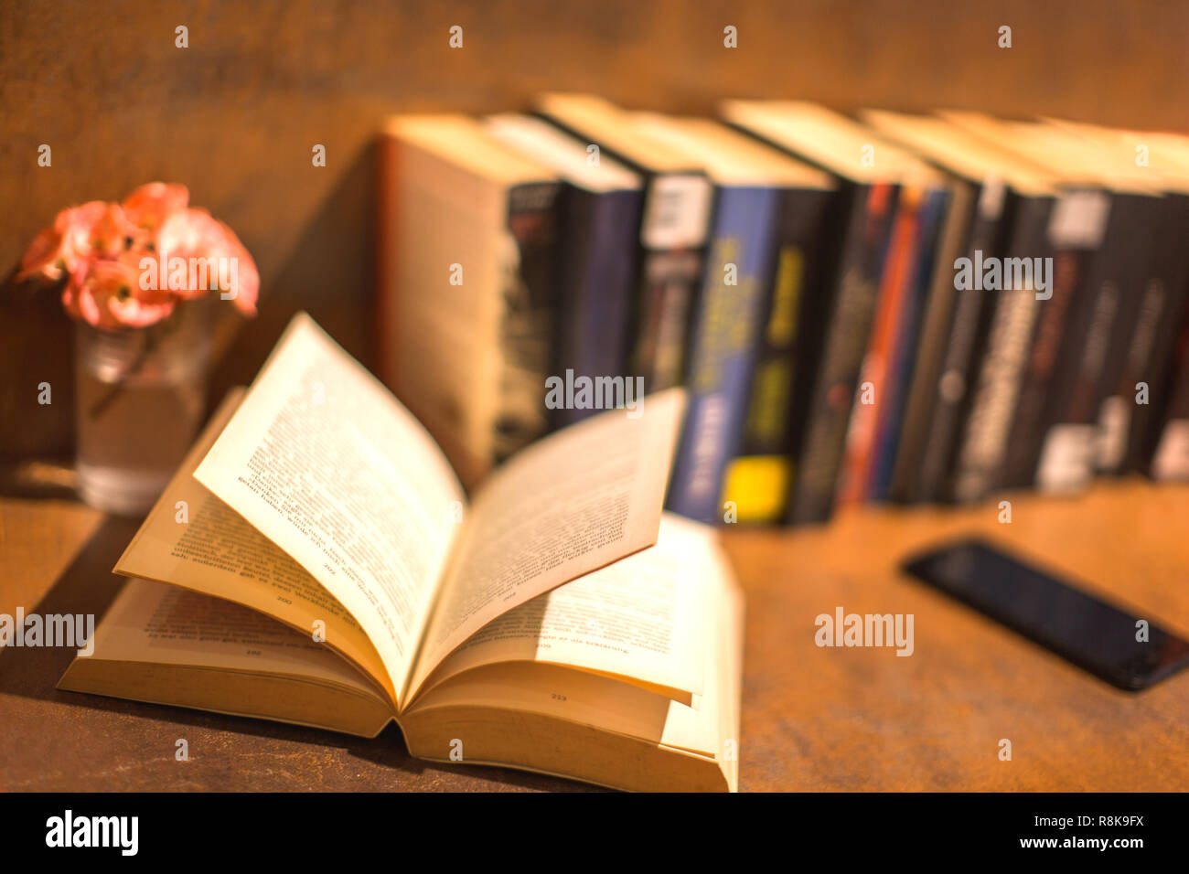 an open book with open pages and mobile phone and flower and books in ...