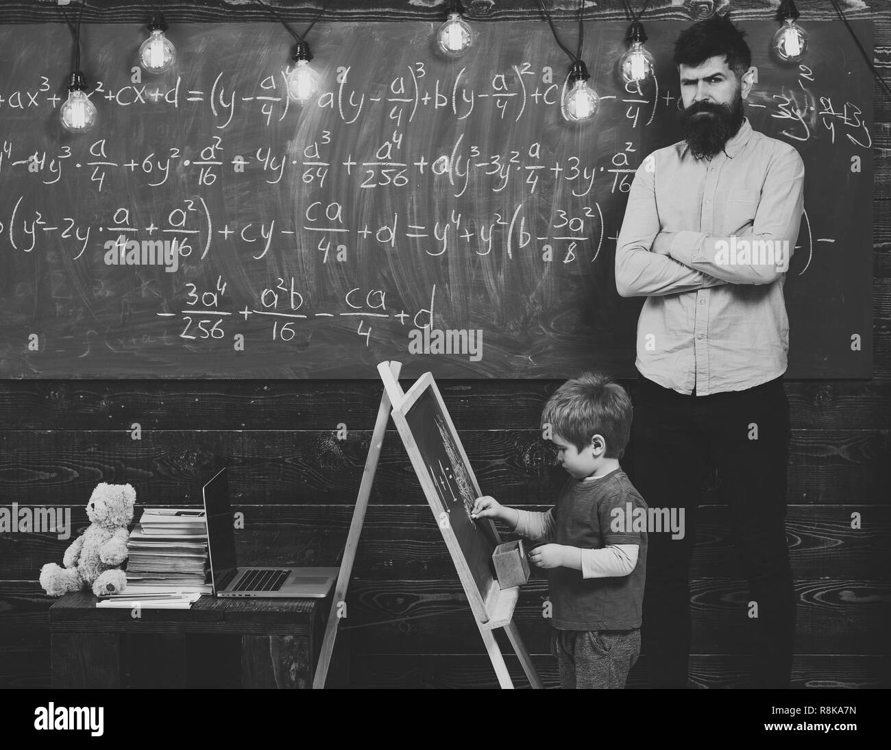 Strict math teacher checking pupil s work. Blond schoolboy solving ...