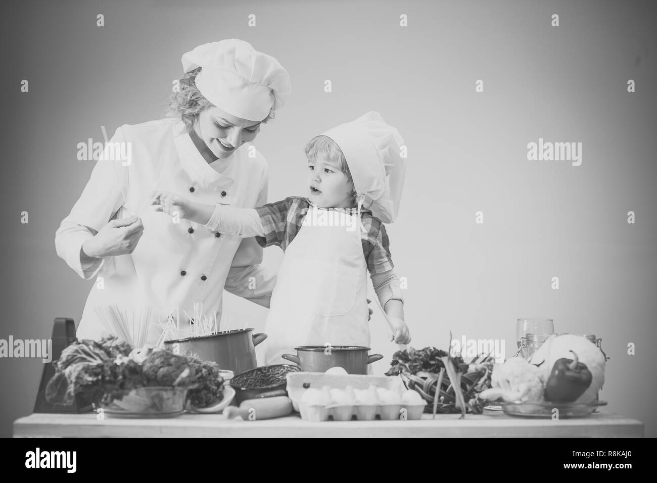 Mom and kid with smiling face cooking spaghetti together Stock Photo ...