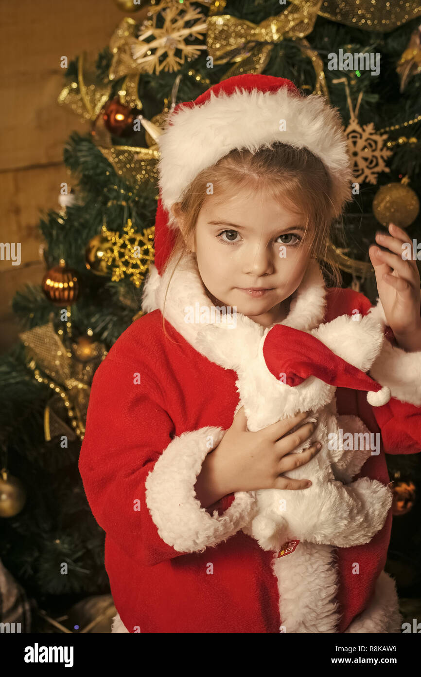Santa claus kid at Christmas tree Stock Photo - Alamy