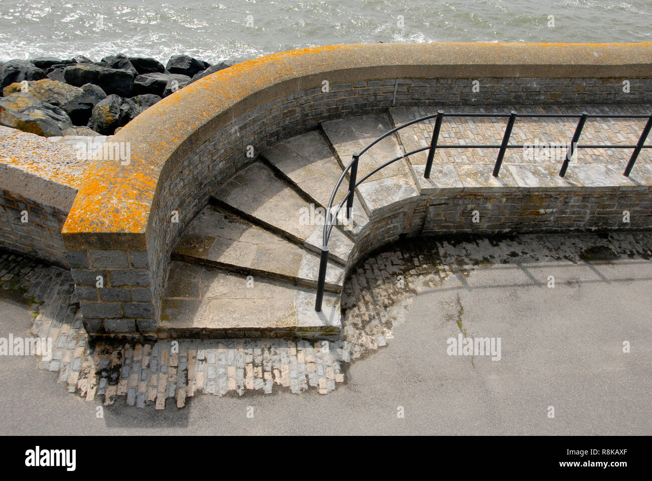 Set of shallow steps on curve leading to promenade behind sea wall ...