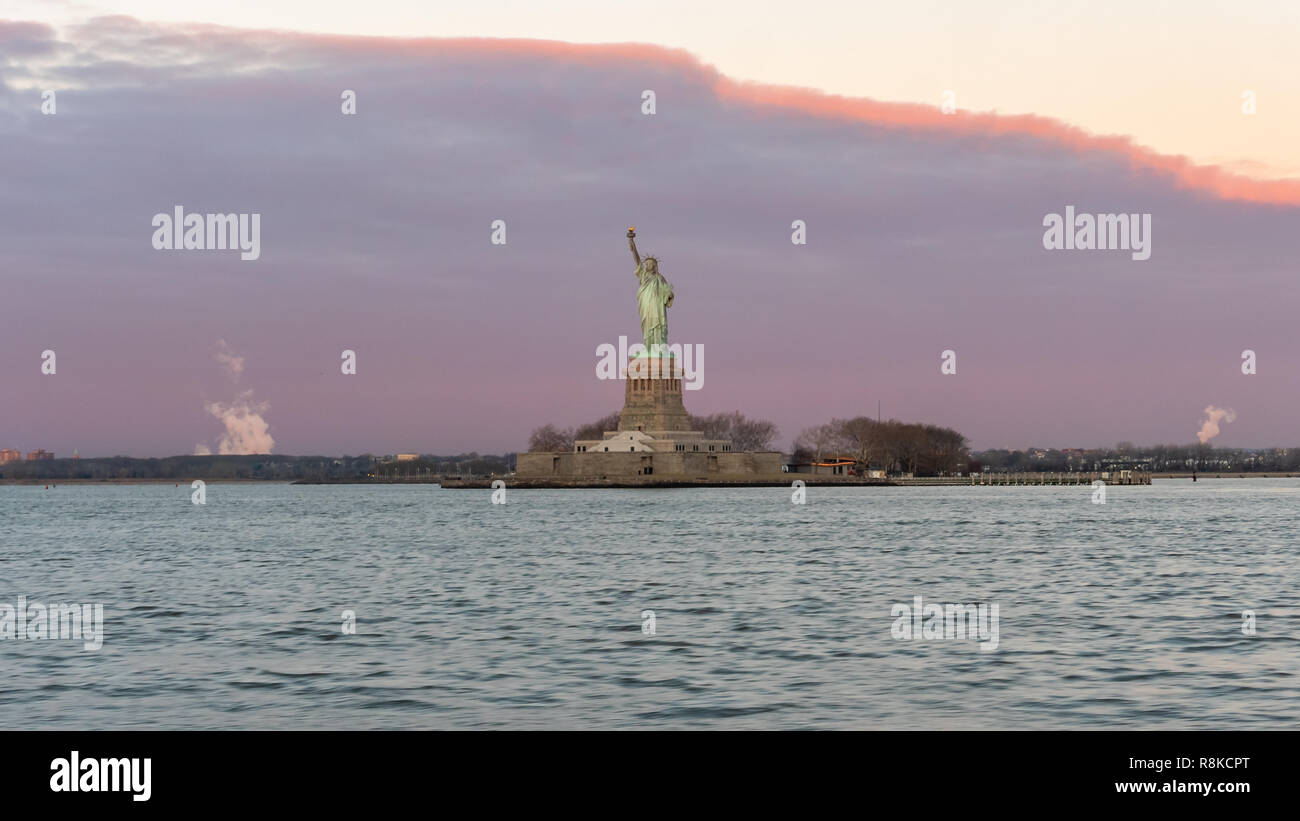 View of the Statue of Liberty With Purple Clouds Behind In a Cold ...