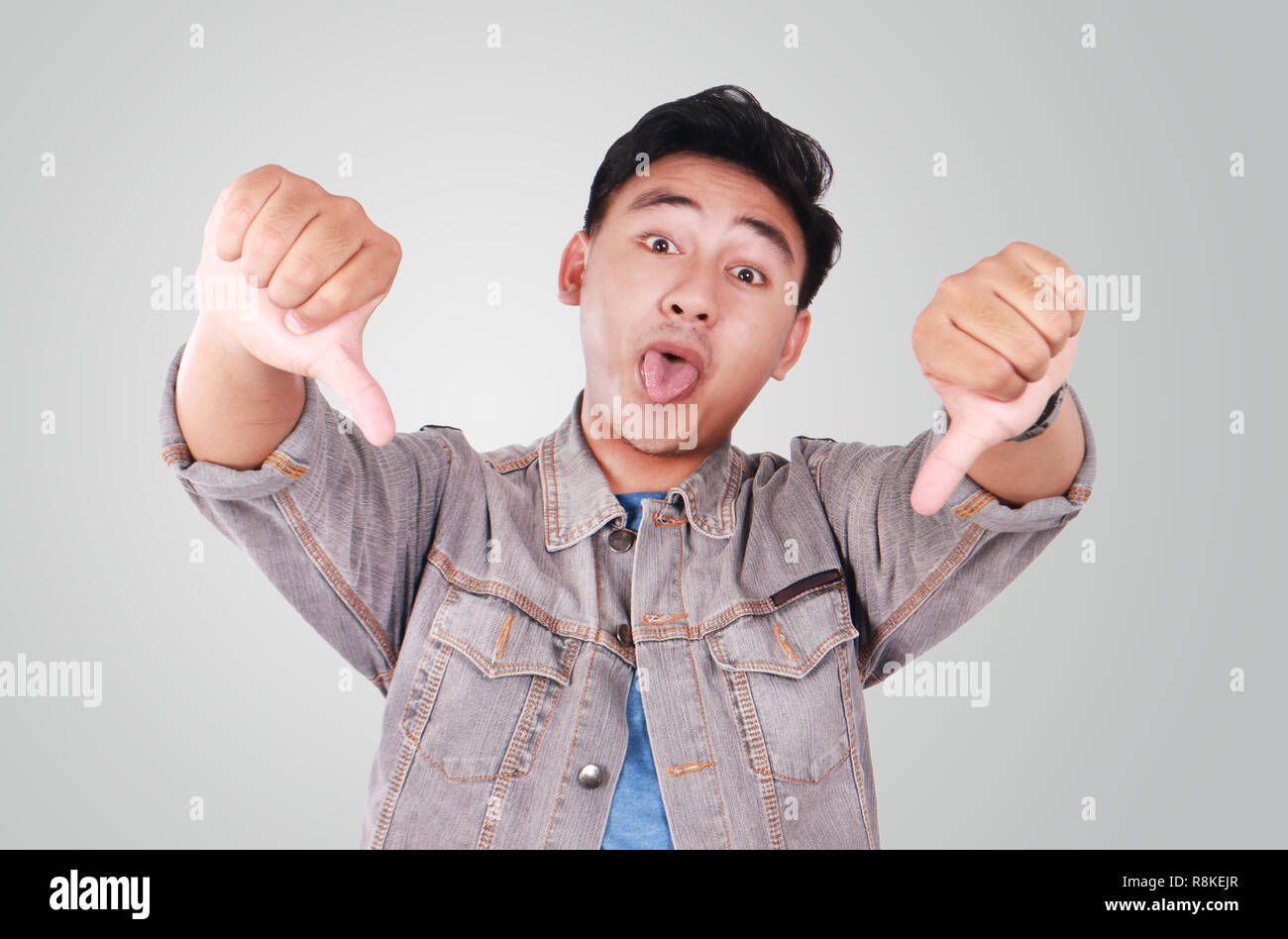 Photo image portrait of a cute young Asian man doing mocking gesture ...