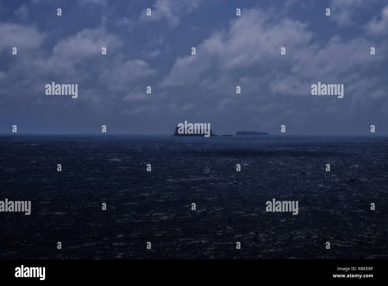 The Ghost Ship. A ship at the horizon passing behind the small island ...