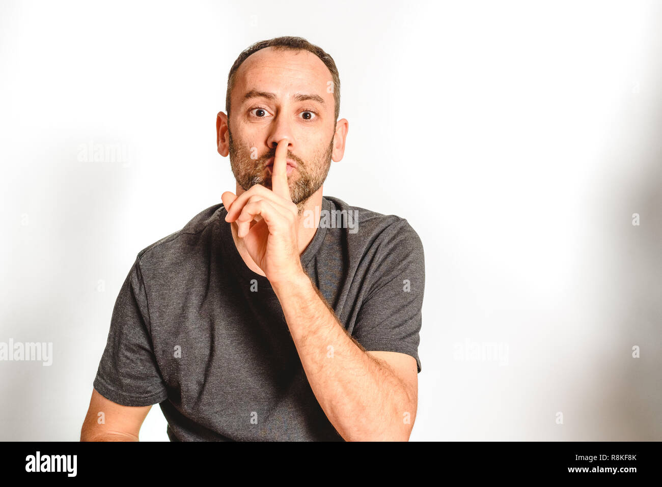 Man in studio asking for silence with a wave of his hand putting a ...
