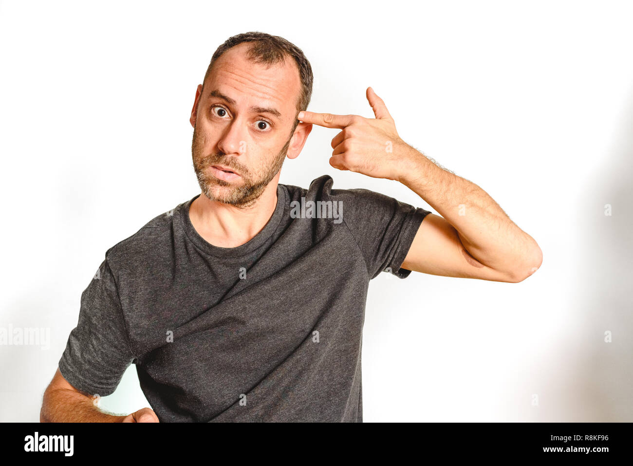 Man in overwhelmed studio pointing with hand to head, model expressions ...