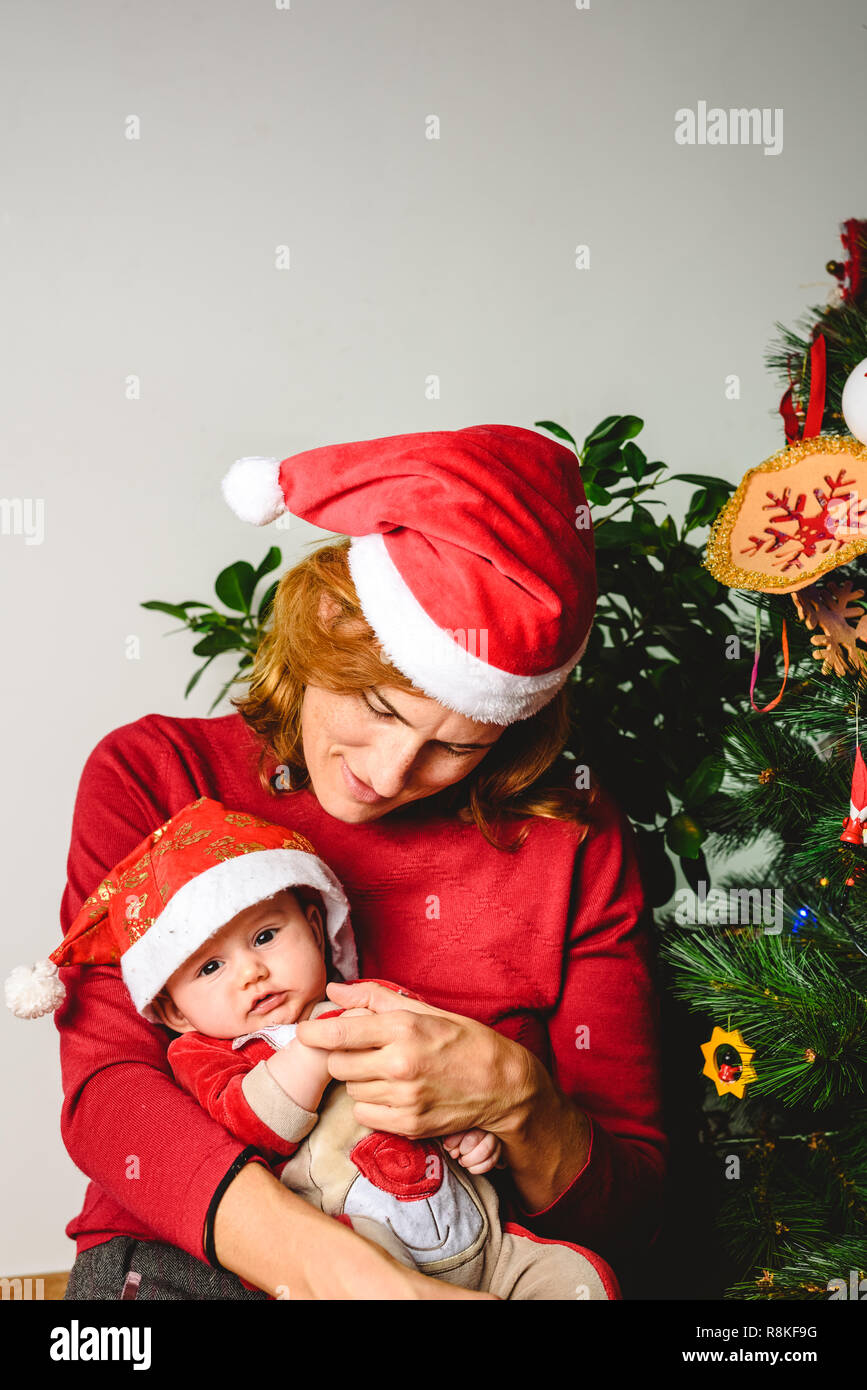 Baby girl dressed as Santa Claus lovingly embraced by her protective ...