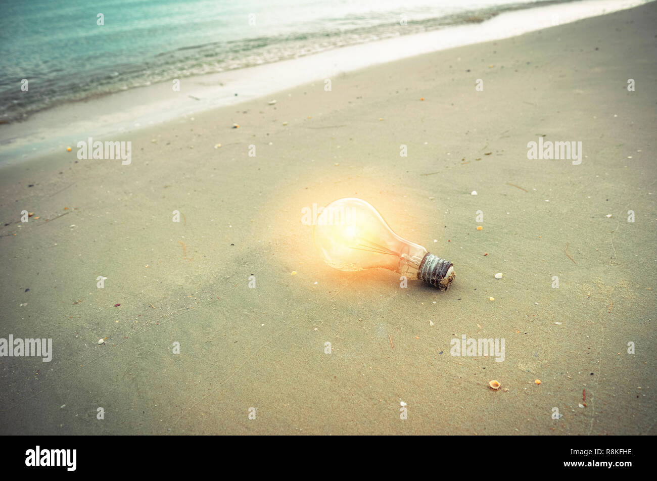 light bulb on beach / Idea concept light bulb with orange lighting on ...