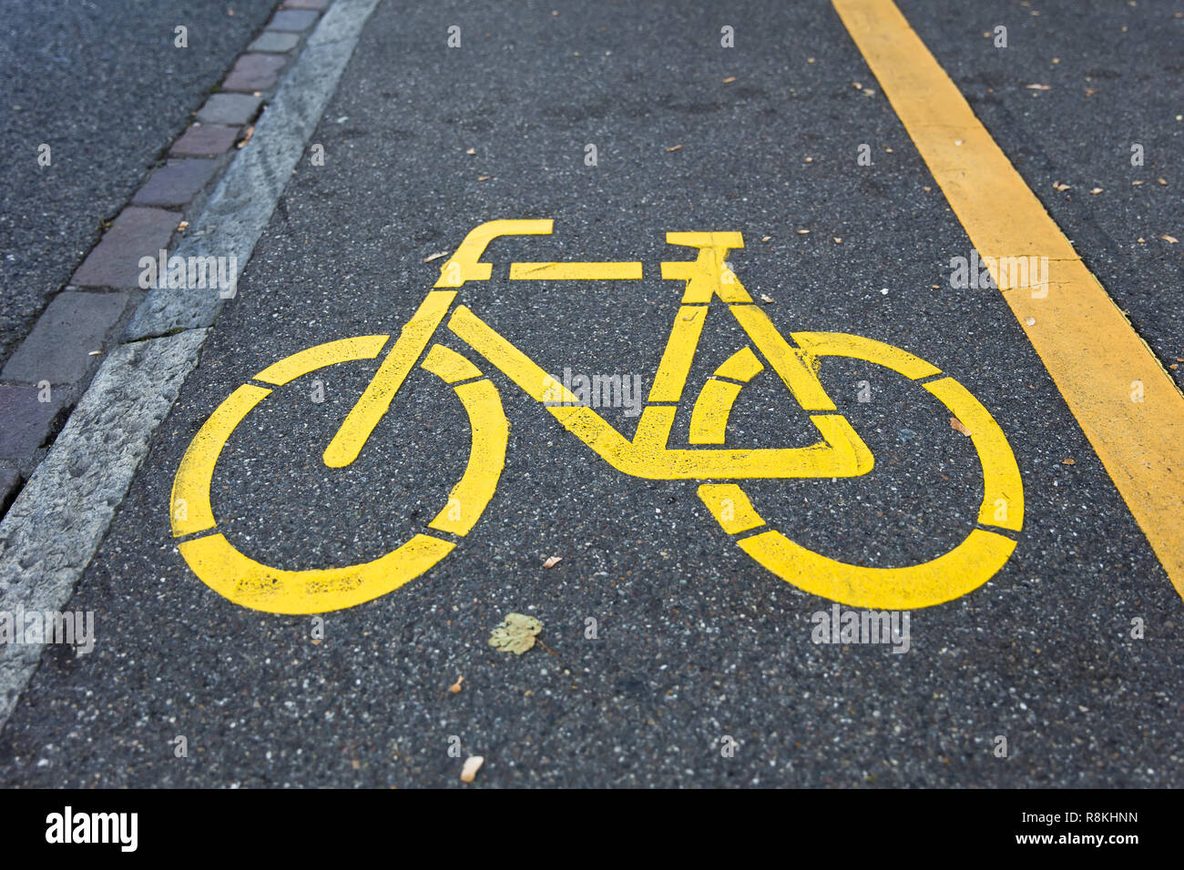 Closeup of the yellow bicycle sign path on the road Stock Photo - Alamy