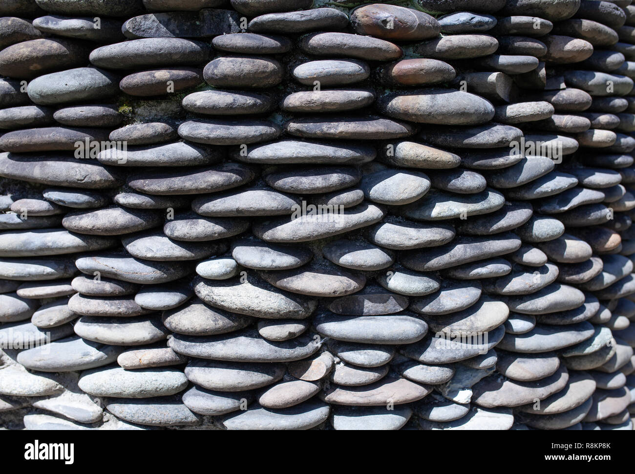 River pebble gravel round stone wall patterned for background. Gray ...