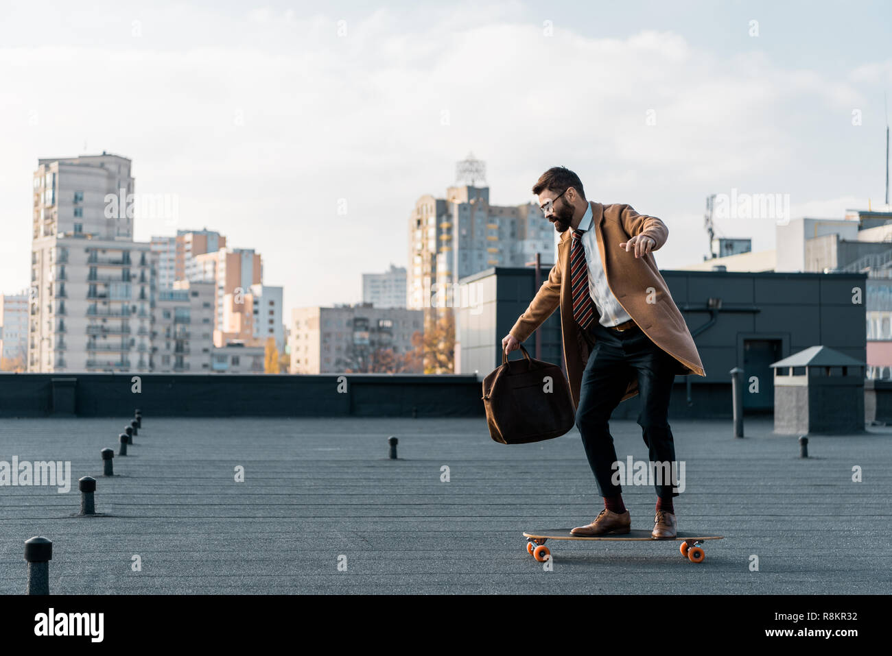 side view of businessman riding on penny board with bag in hand Stock ...