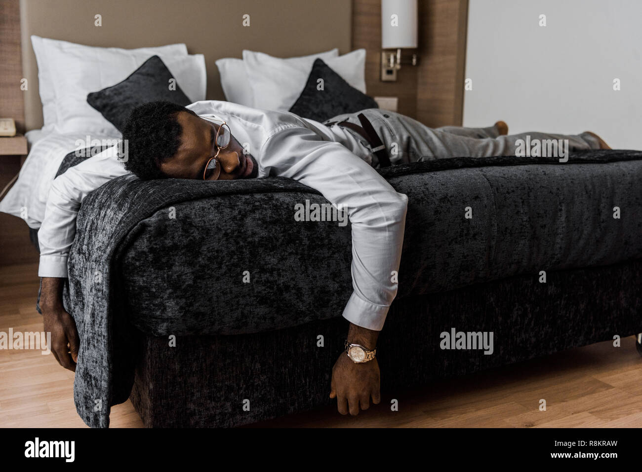 exhausted african american man sleeping on bed in hotel room Stock ...