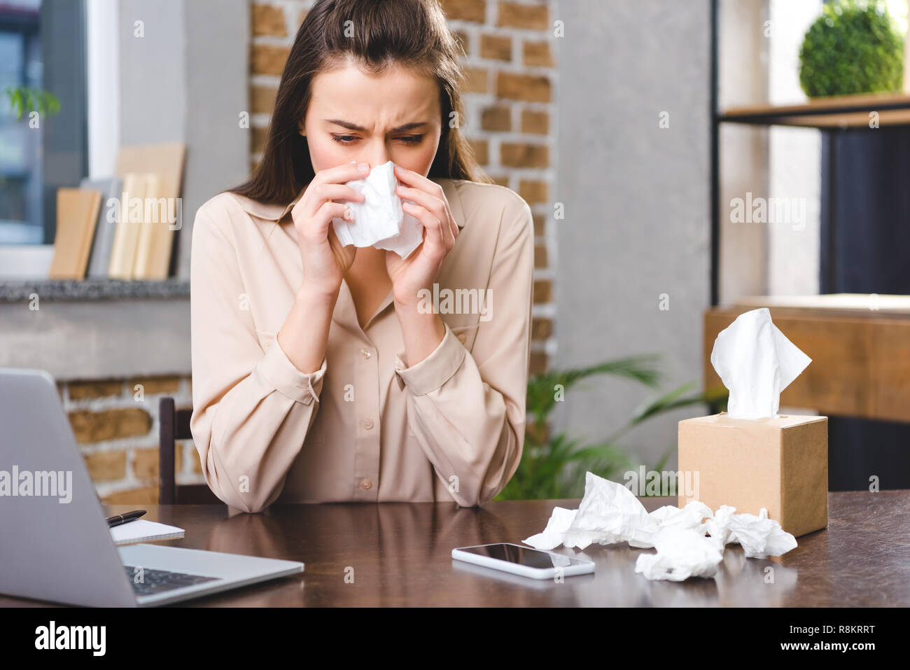 young businesswoman suffering from allergy at workplace Stock Photo - Alamy