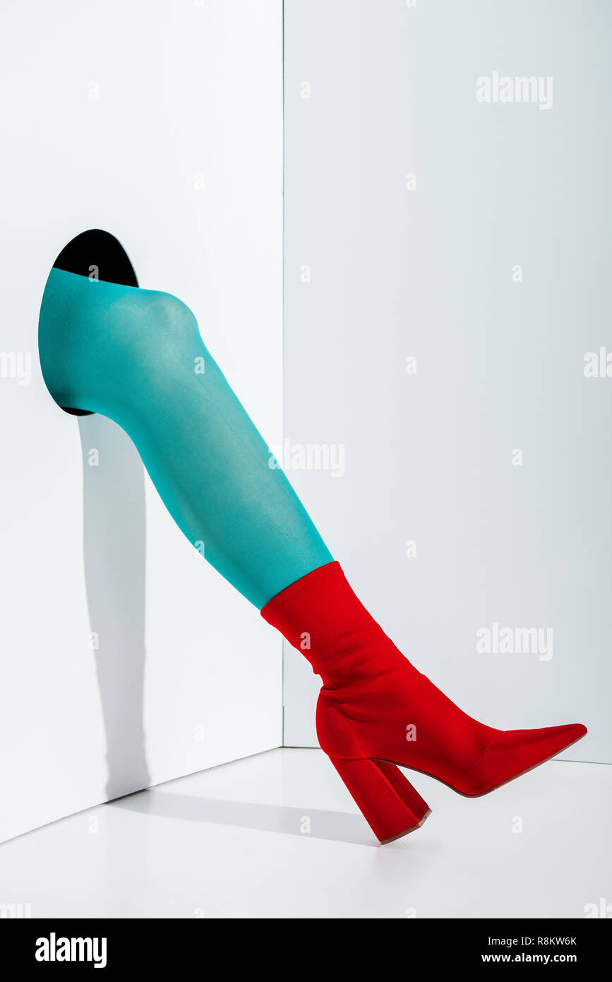 cropped image of woman showing leg in turquoise tights and red shoe in ...