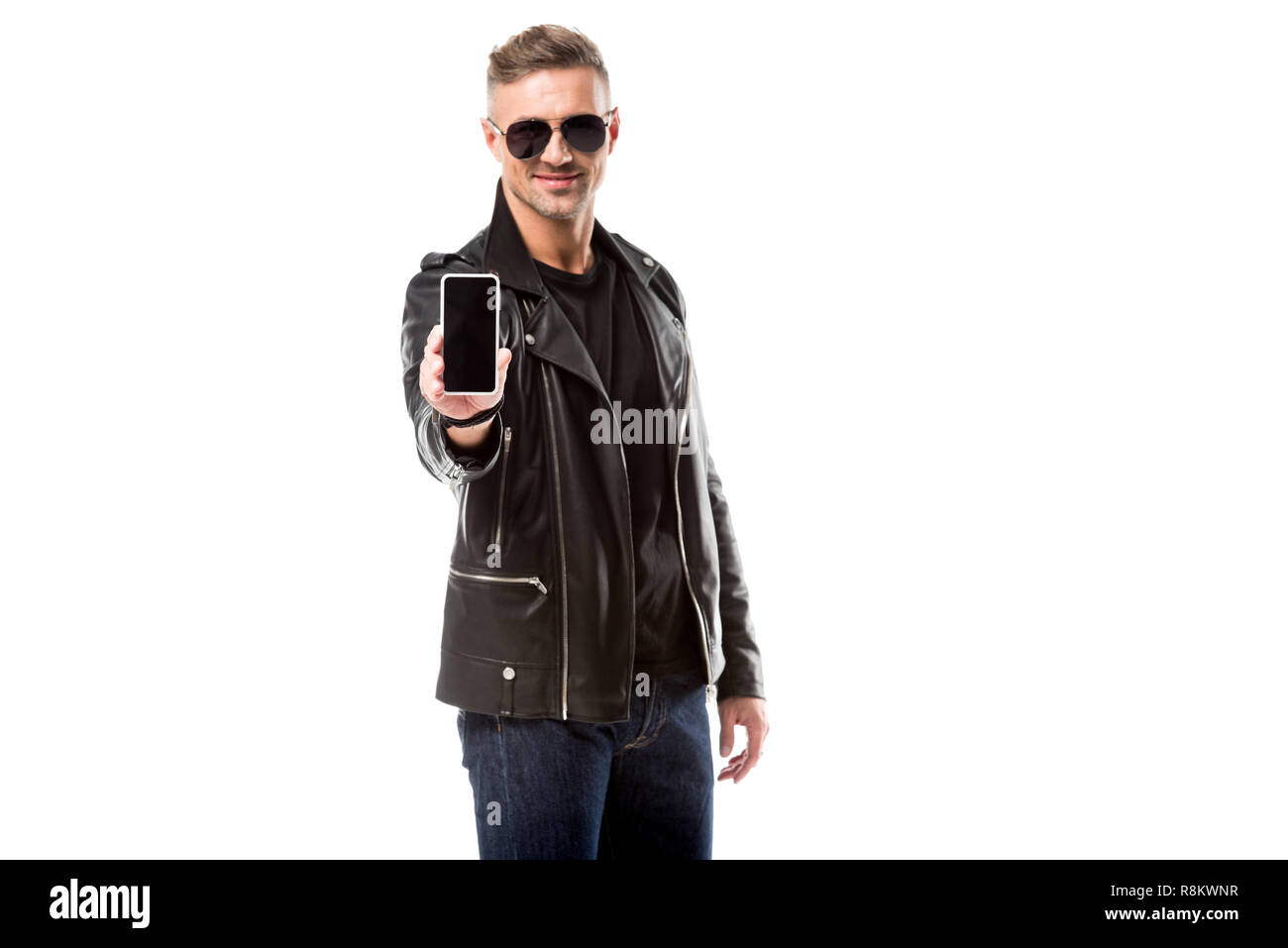 stylish adult man in leather jacket presenting smartphone with blank ...