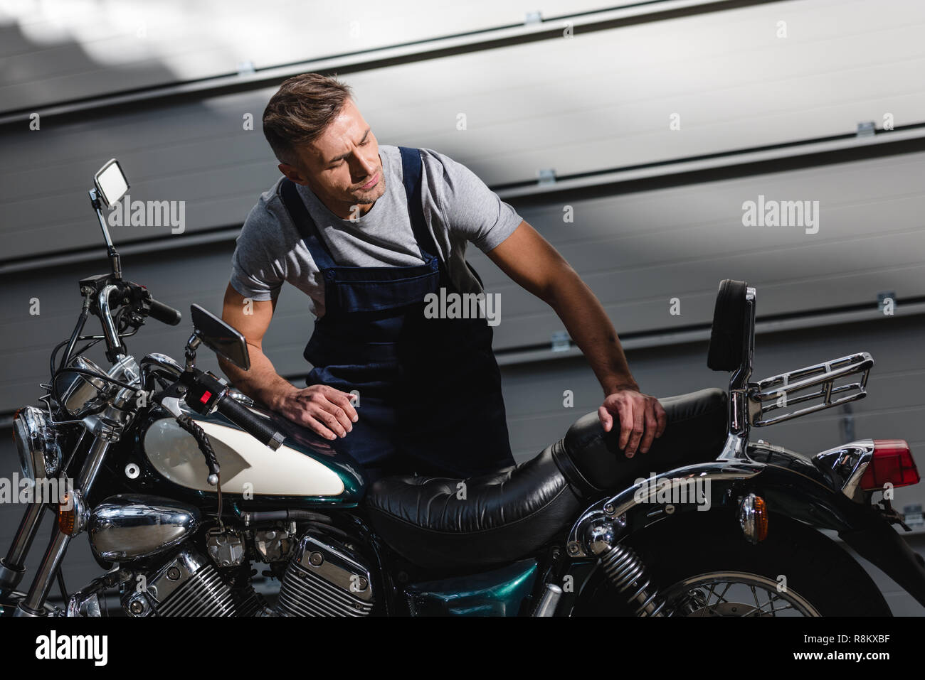 side view of mechanic checking back wheel in garage Stock Photo - Alamy