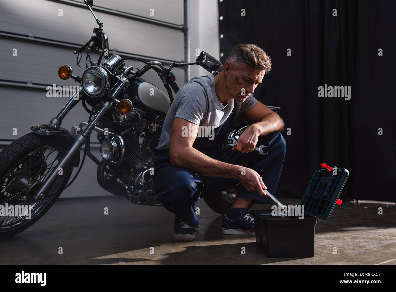 mechanic putting tools away after fixing motorbike in garage Stock ...