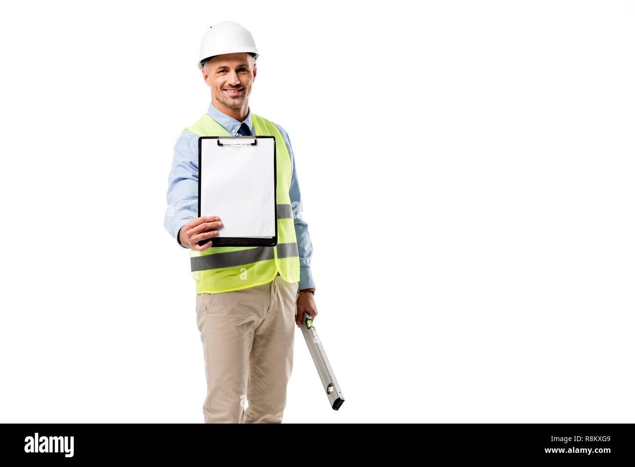 smiling engineer holding clipboard with blank sheet and spirit level ...