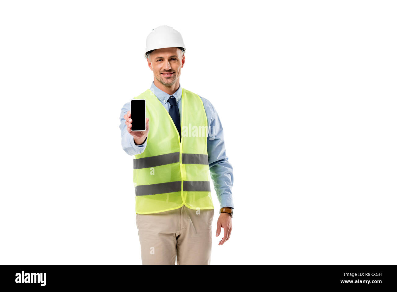 smiling engineer looking at camera and holding smartphone with blank ...